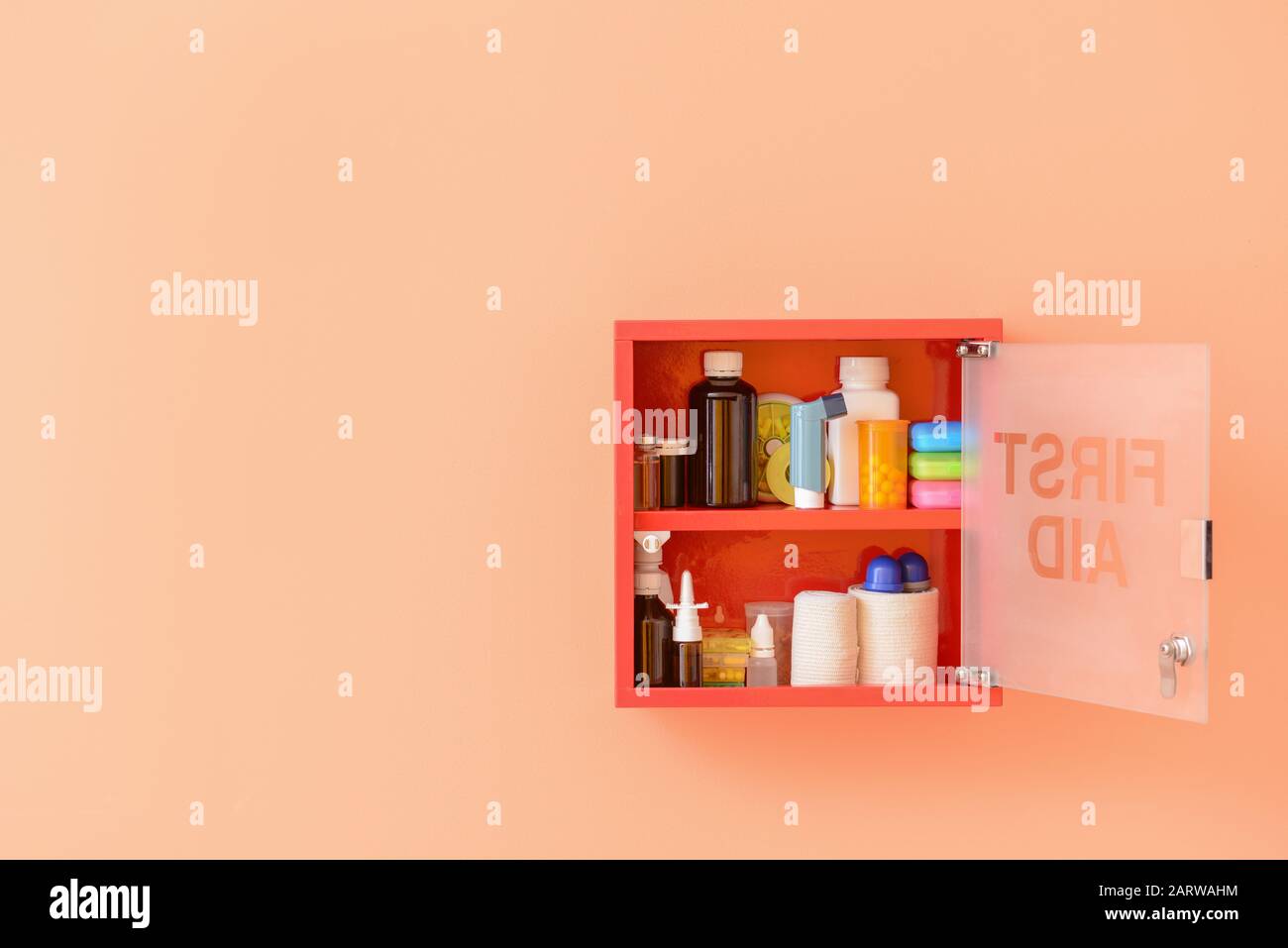 First aid kit hanging on color wall Stock Photo - Alamy