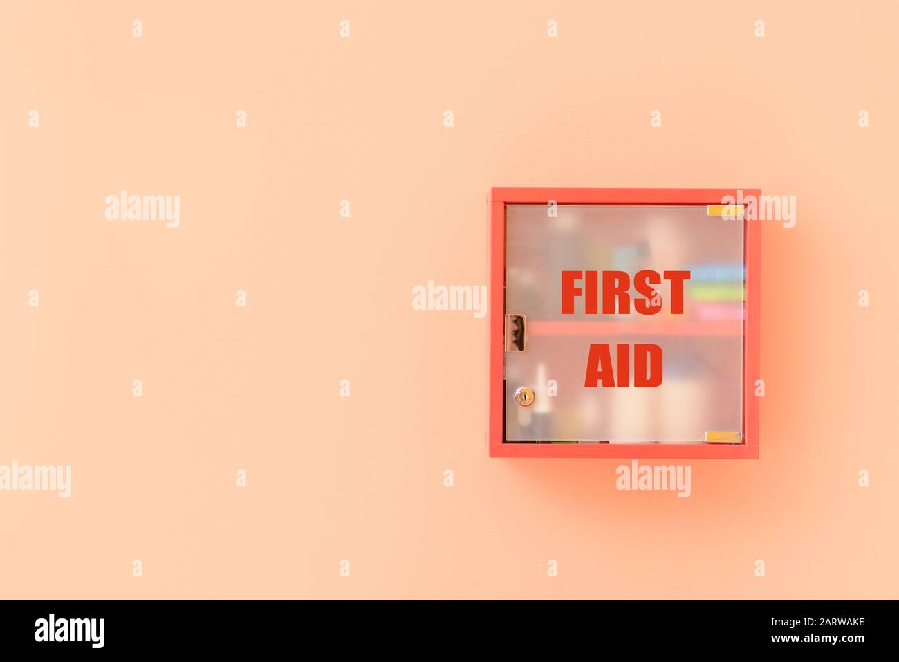 First aid kit hanging on color wall Stock Photo - Alamy