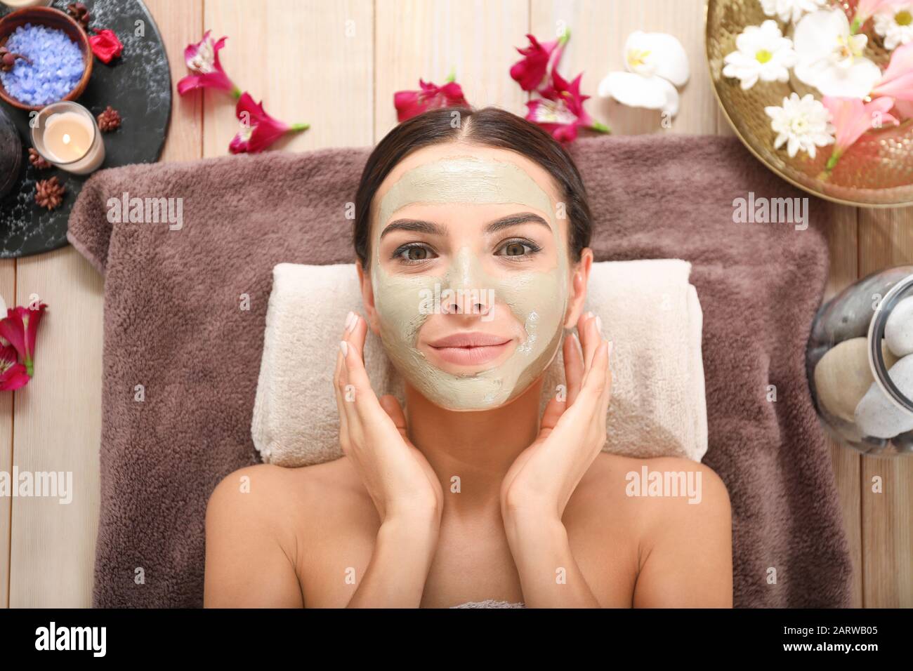 Beautiful young woman with facial mask relaxing in spa salon Stock ...