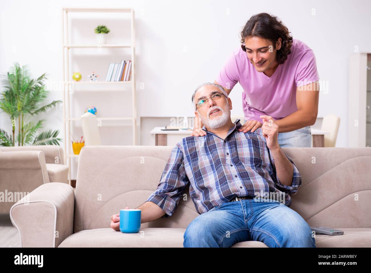 The young student and his old grandpa at home Stock Photo - Alamy