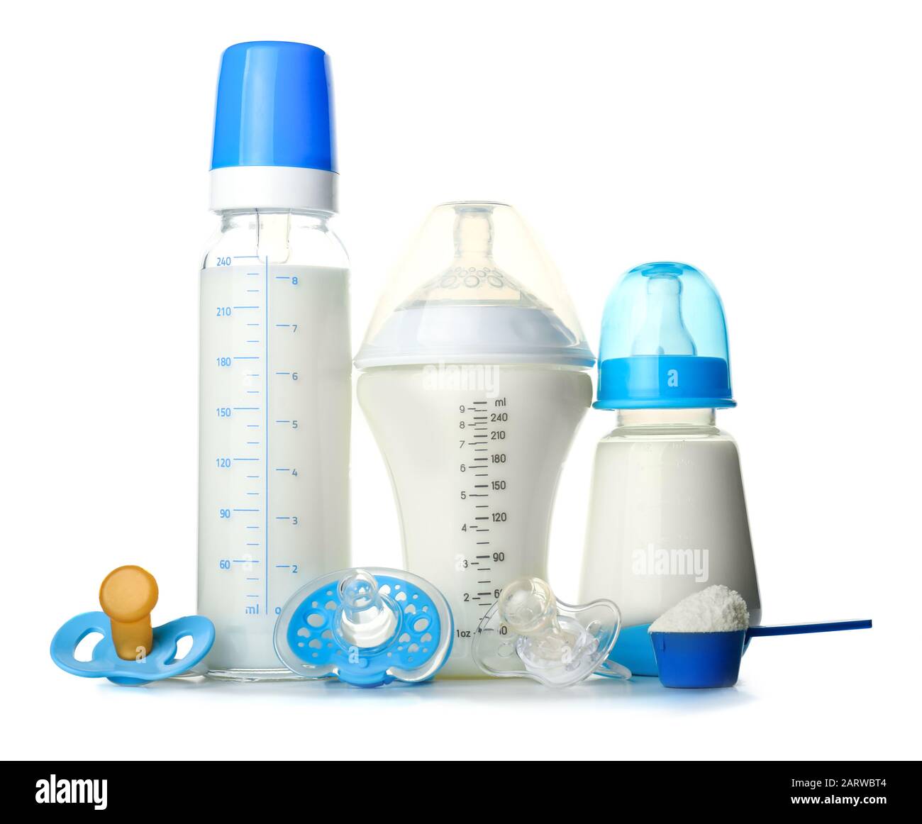 Bottles of milk with pacifiers and baby formula on white background ...