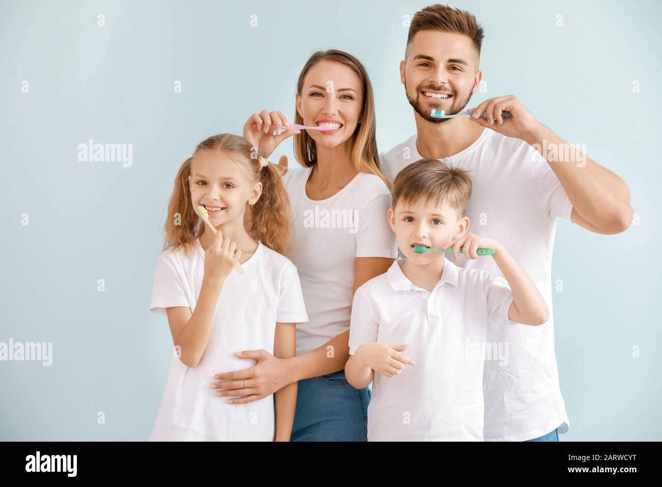 Portrait of family brushing teeth on light background Stock Photo - Alamy