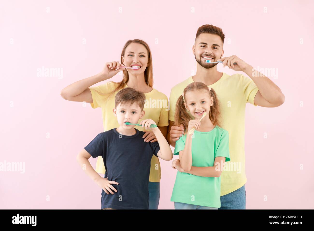 Portrait of family brushing teeth on color background Stock Photo - Alamy