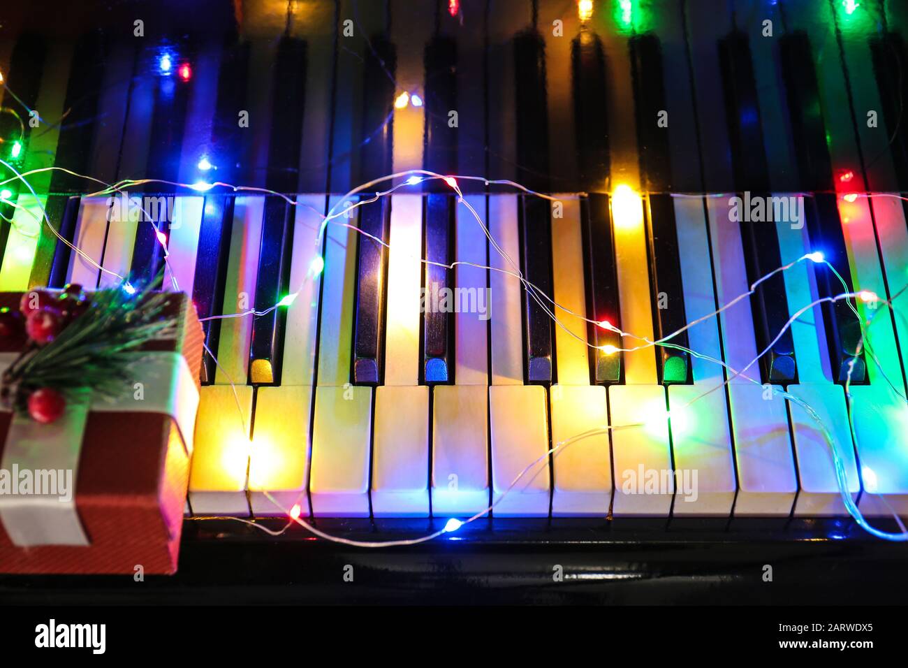 Piano keyboard with Christmas lights and gift box Stock Photo - Alamy
