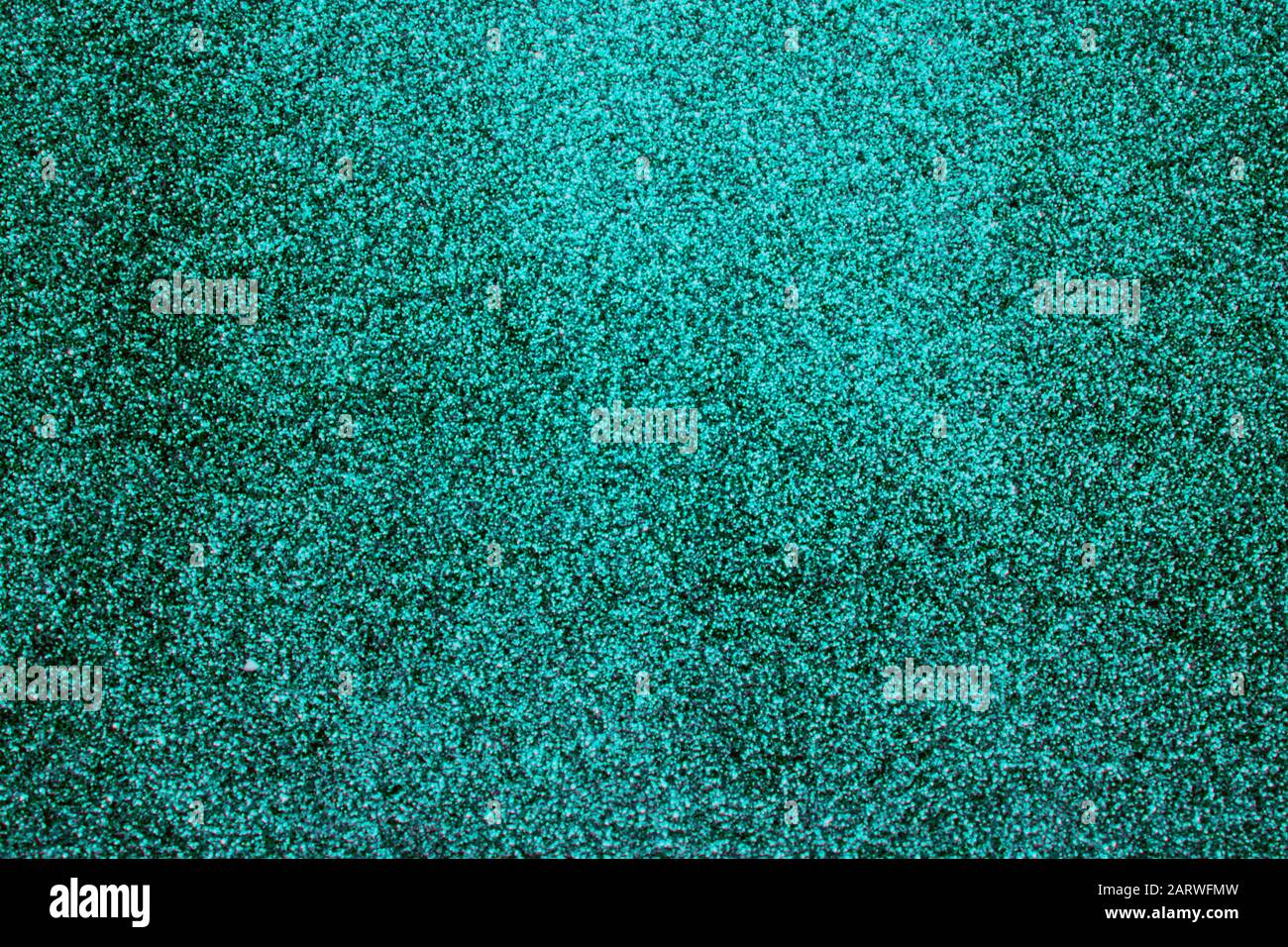 rough turquoise background with black spots on it and bright spots ...