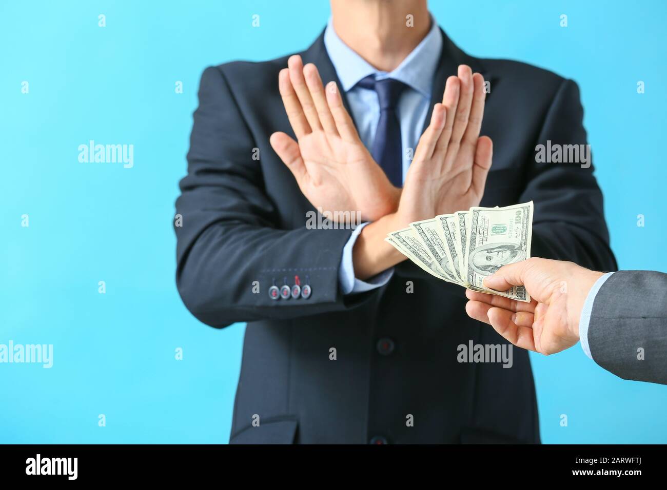 Businessman refusing to take bribe against color background Stock Photo ...
