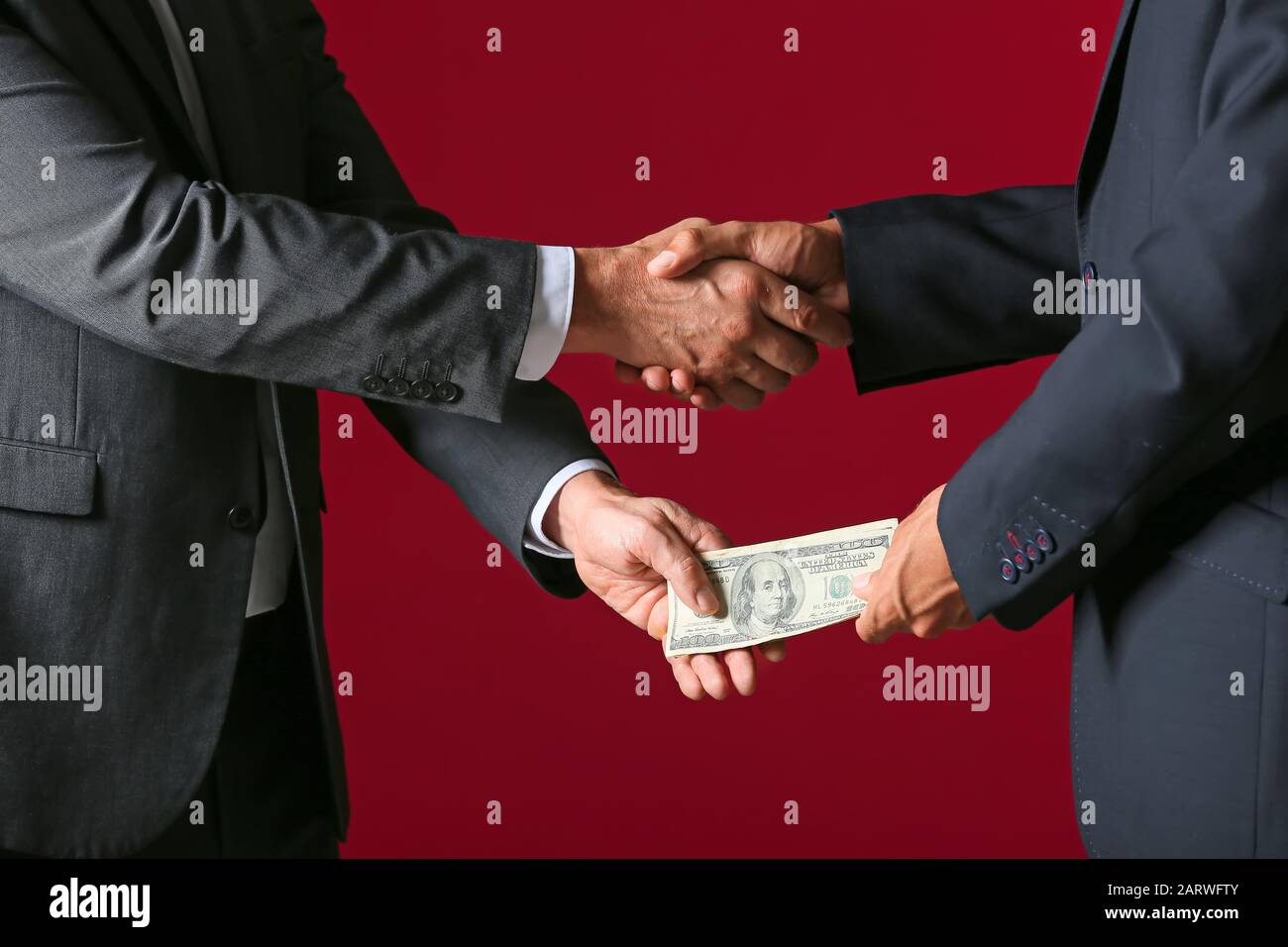 Businessman taking bribe against color background Stock Photo - Alamy