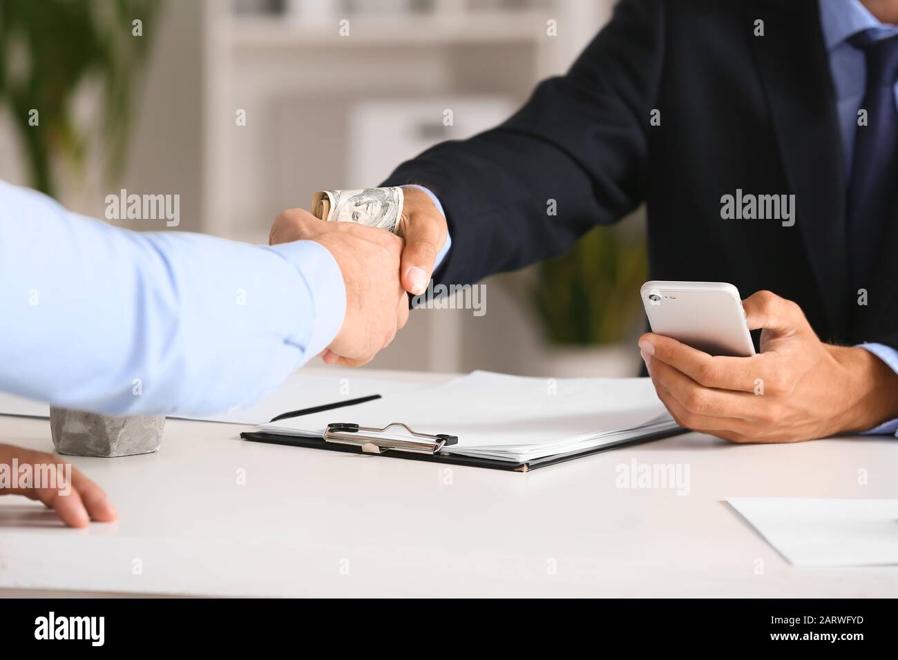 Businessman taking bribe at workplace Stock Photo - Alamy