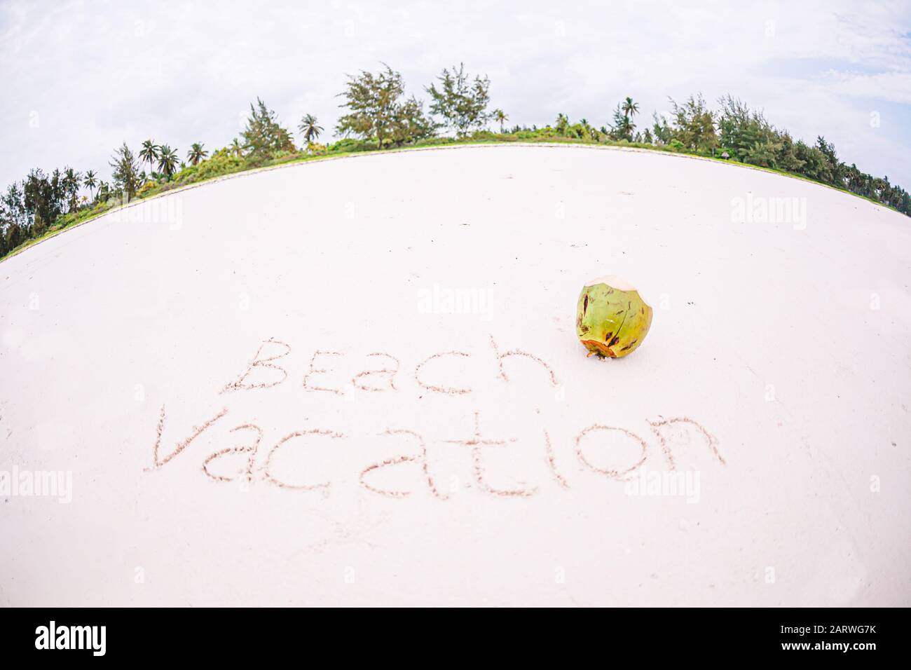 Beach vacation handwritten on sandy beach with soft ocean wave on ...