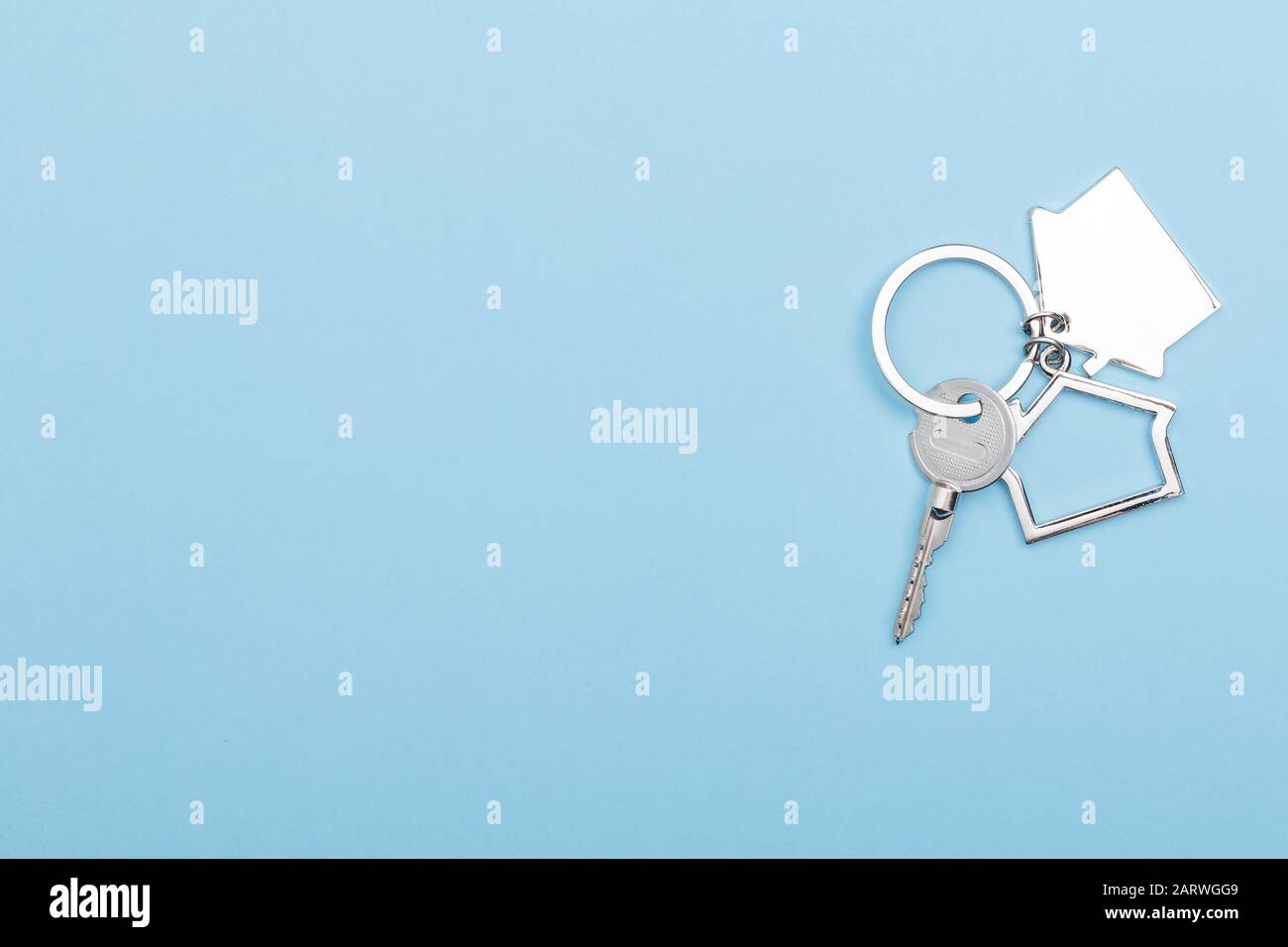 House keys with trinket on color background, top view with copy space ...