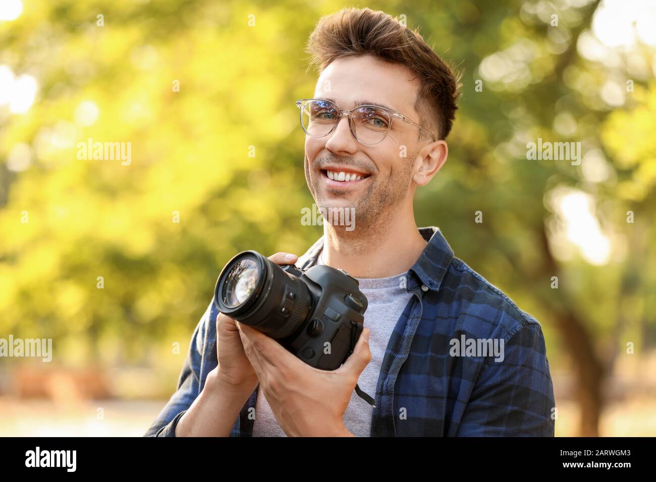 Handsome male photographer with camera outdoors Stock Photo - Alamy