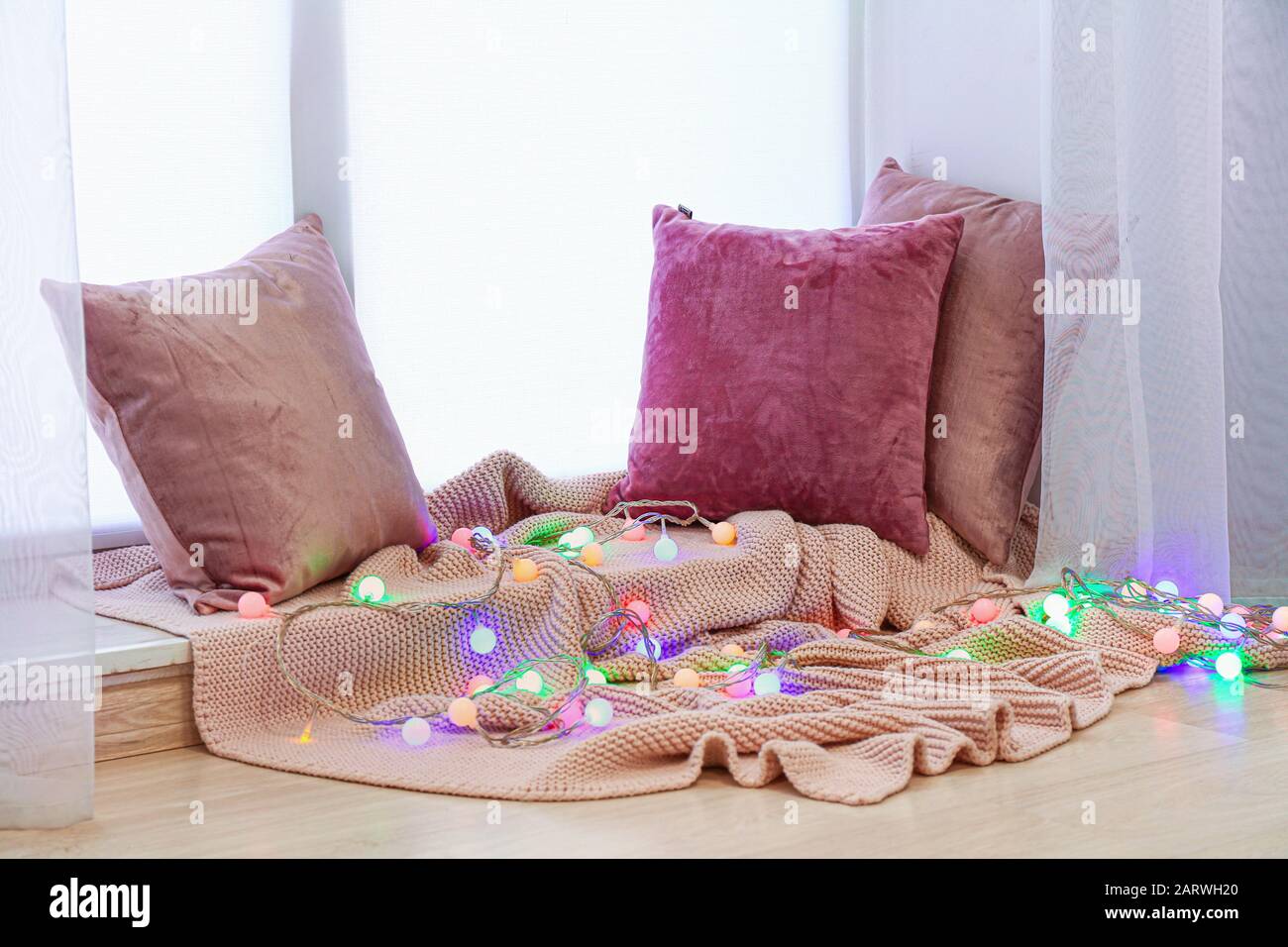 Beautiful glowing garland with pillows and plaid on window sill Stock ...