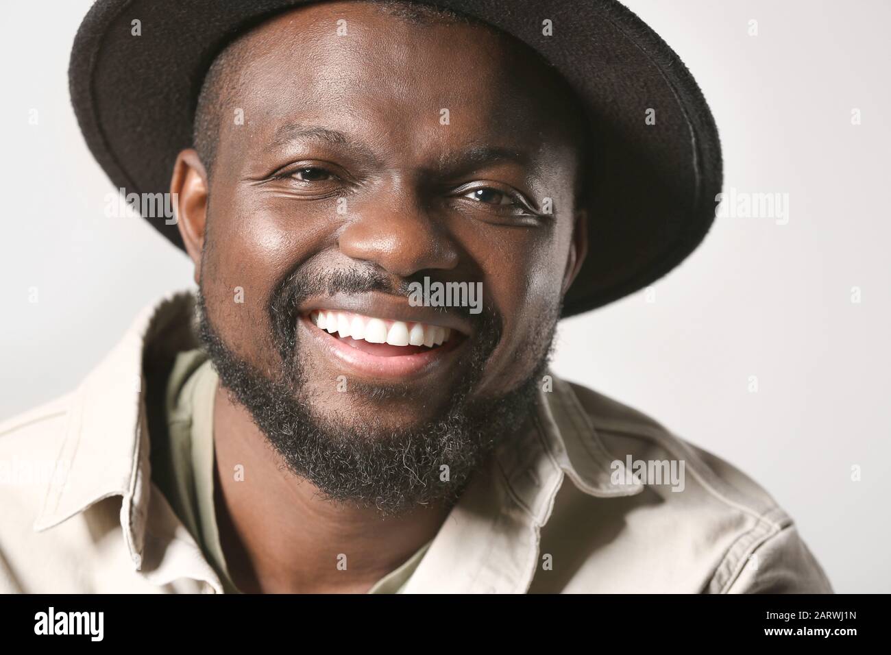 Portrait of happy African-American man on grey background Stock Photo ...