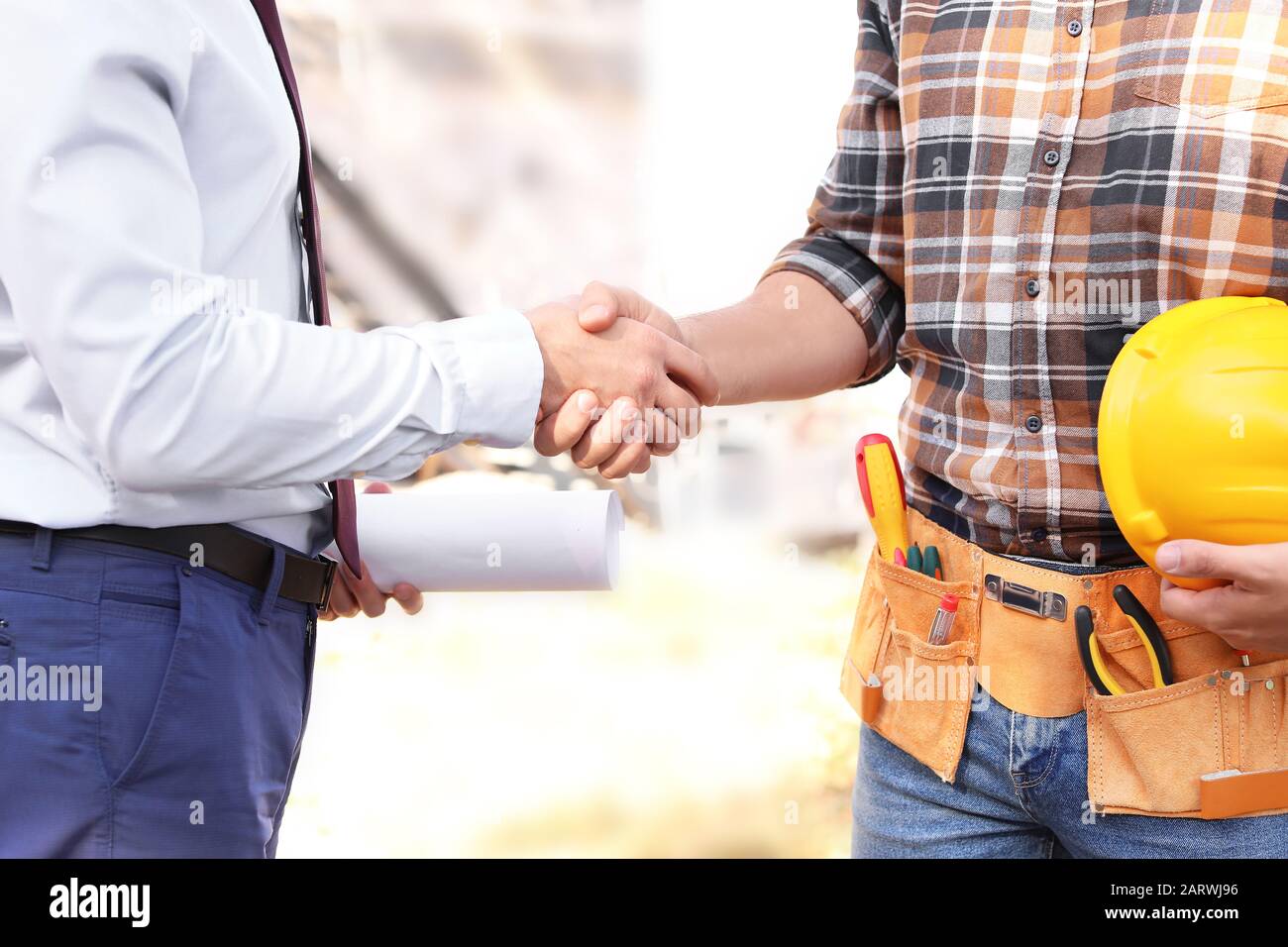 Male architect and builder shaking hands outdoors Stock Photo - Alamy