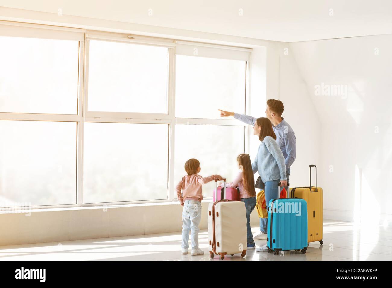 Happy family with luggage in airport Stock Photo - Alamy