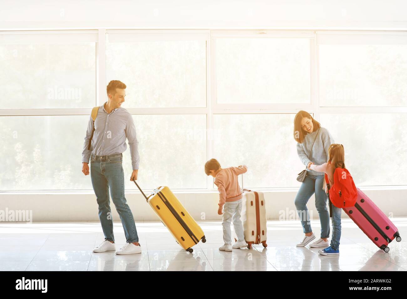 Happy family with luggage in airport Stock Photo - Alamy