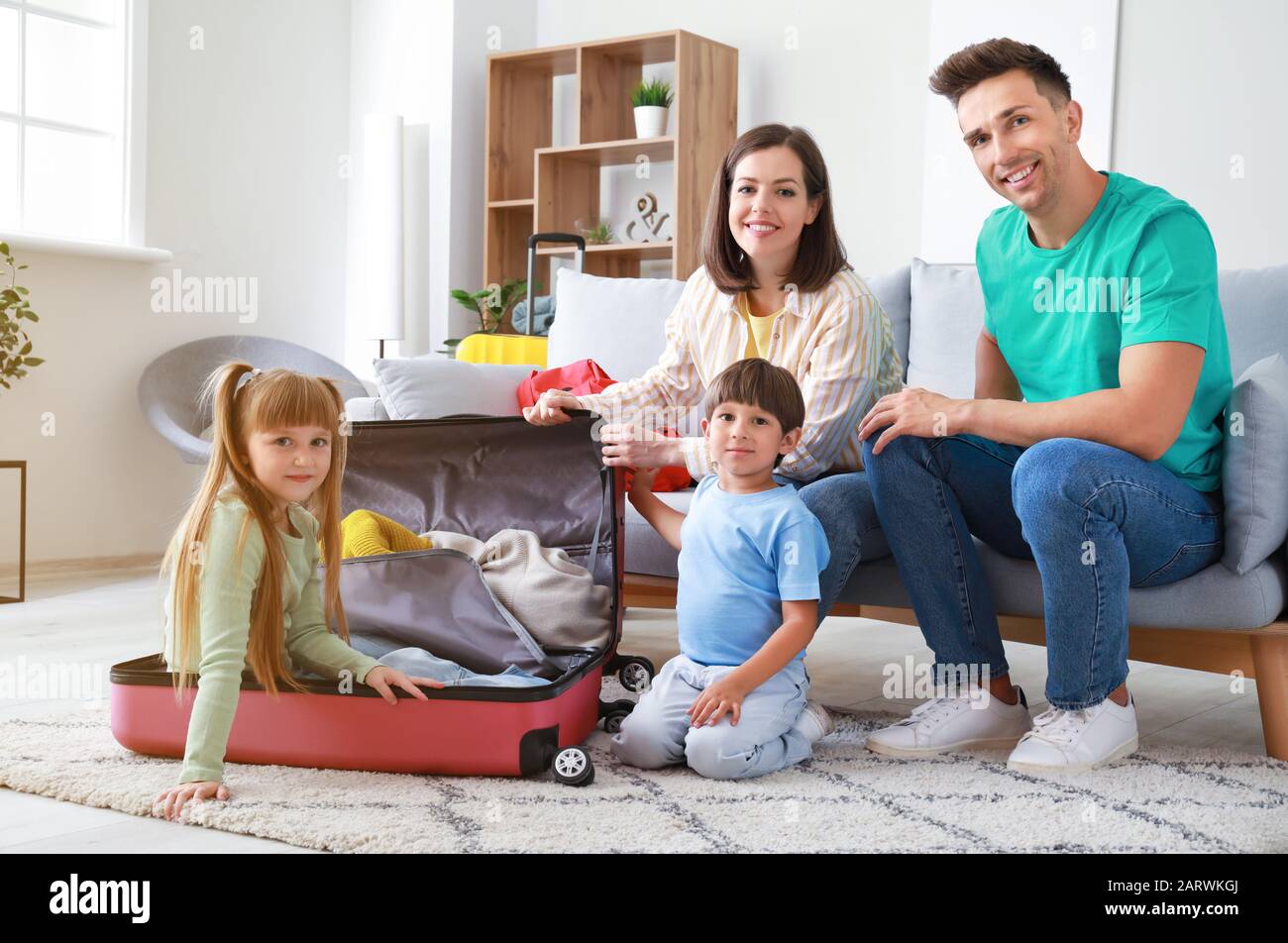 Happy family having fun while packing suitcase at home Stock Photo - Alamy