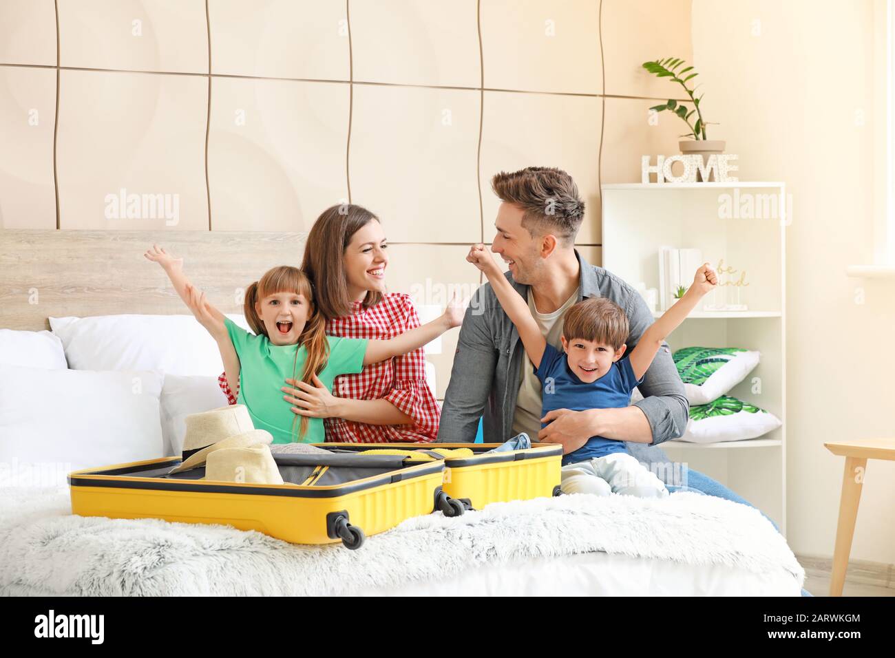Happy family packing suitcase at home Stock Photo - Alamy