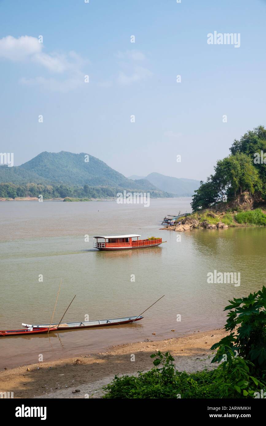 A Boat Plies The Waters Of The Mekong River And Enters The Nam Khan