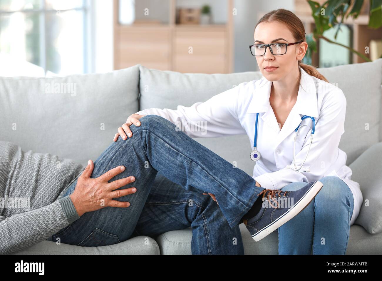 Senior caucasian doctor examining knee hi-res stock photography and ...