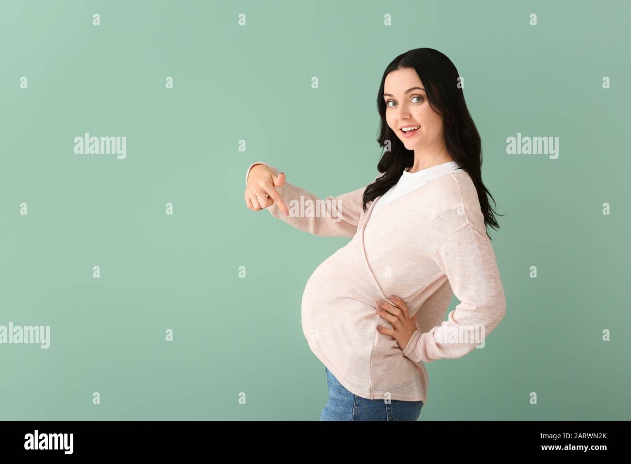 Beautiful young pregnant woman on color background Stock Photo - Alamy