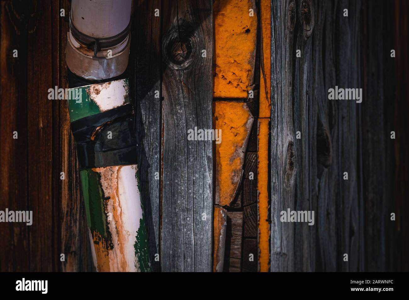 Closeup shot of a wood barn wall with an attached worn out downspout ...