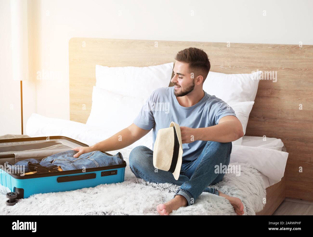 Happy young man tourist packing hi-res stock photography and images - Alamy