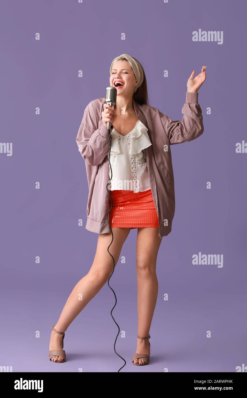 Beautiful young female singer with microphone on color background Stock ...