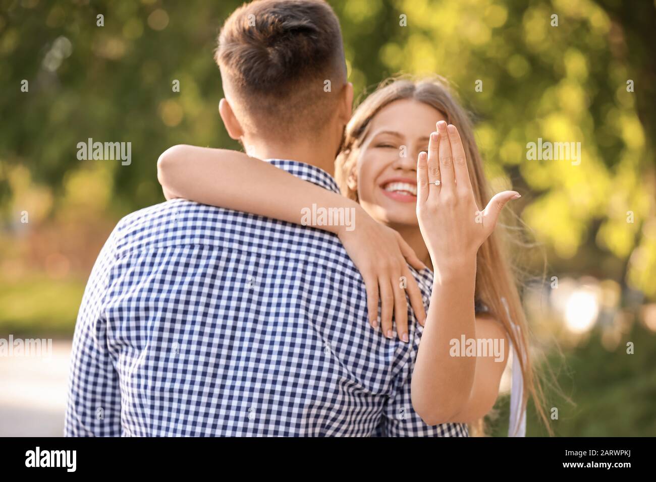 Happy engaged couple hugging outdoors Stock Photo - Alamy