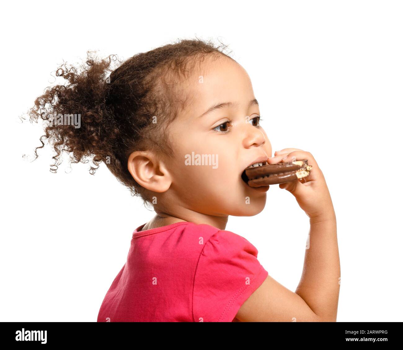 Portrait of little African-American girl eating cookie on white ...
