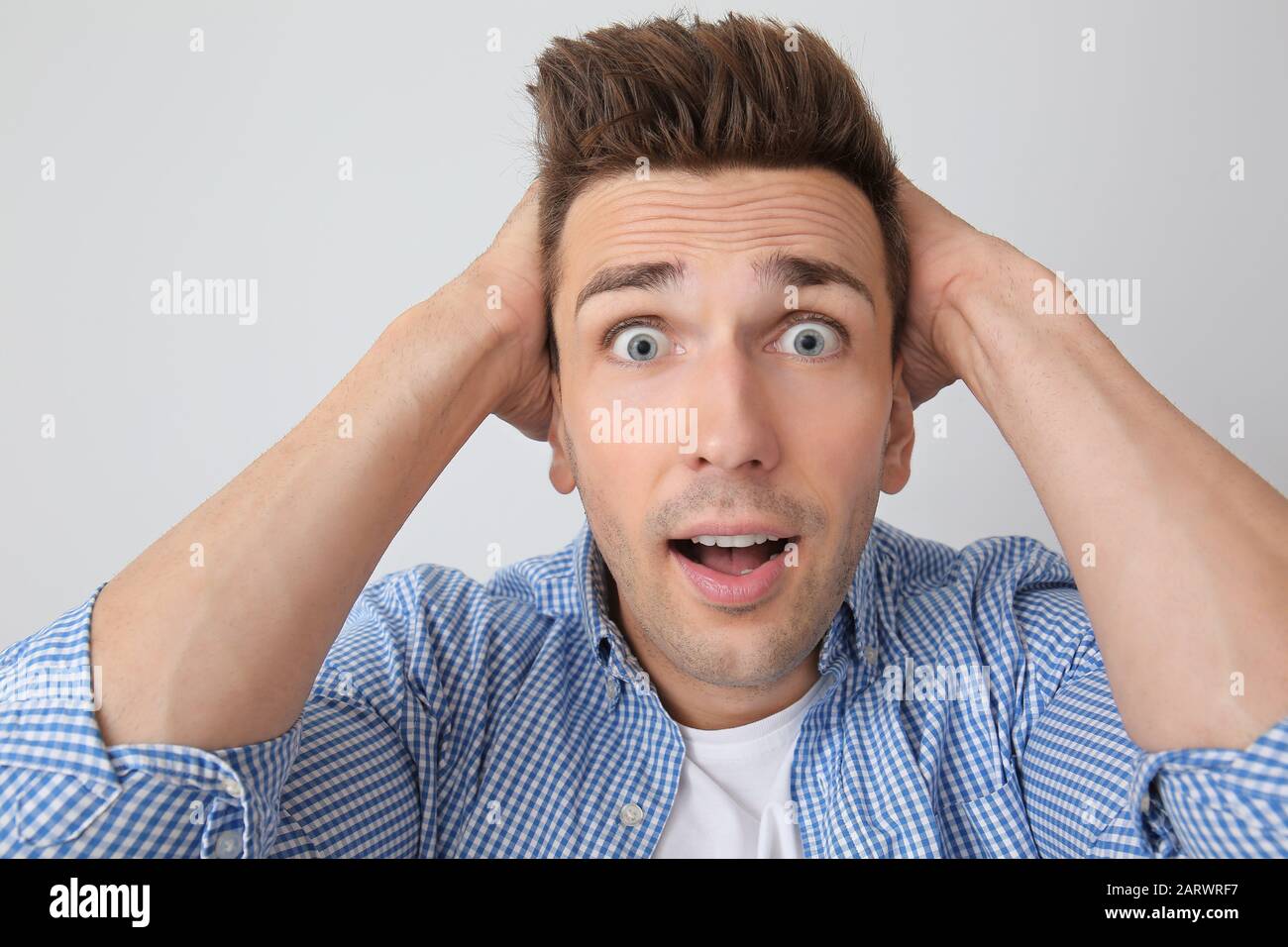 Shocked young man on light background Stock Photo - Alamy