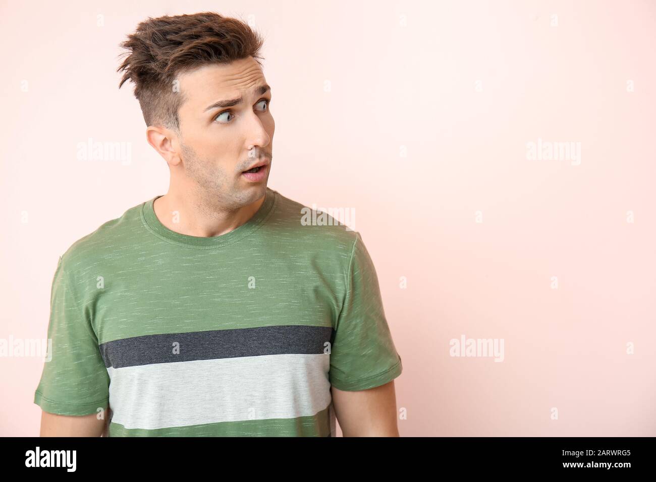 Shocked young man on color background Stock Photo - Alamy