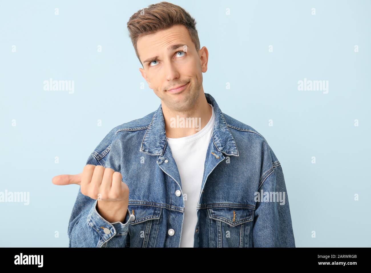 Thoughtful young man on color background Stock Photo - Alamy