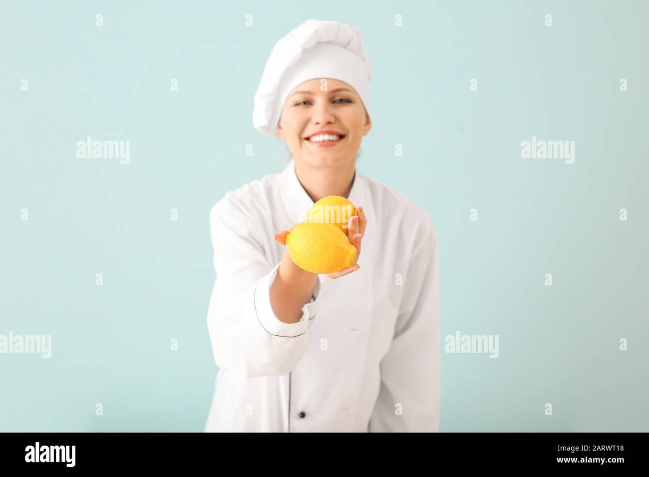 Beautiful female chef with lemons on light background Stock Photo - Alamy