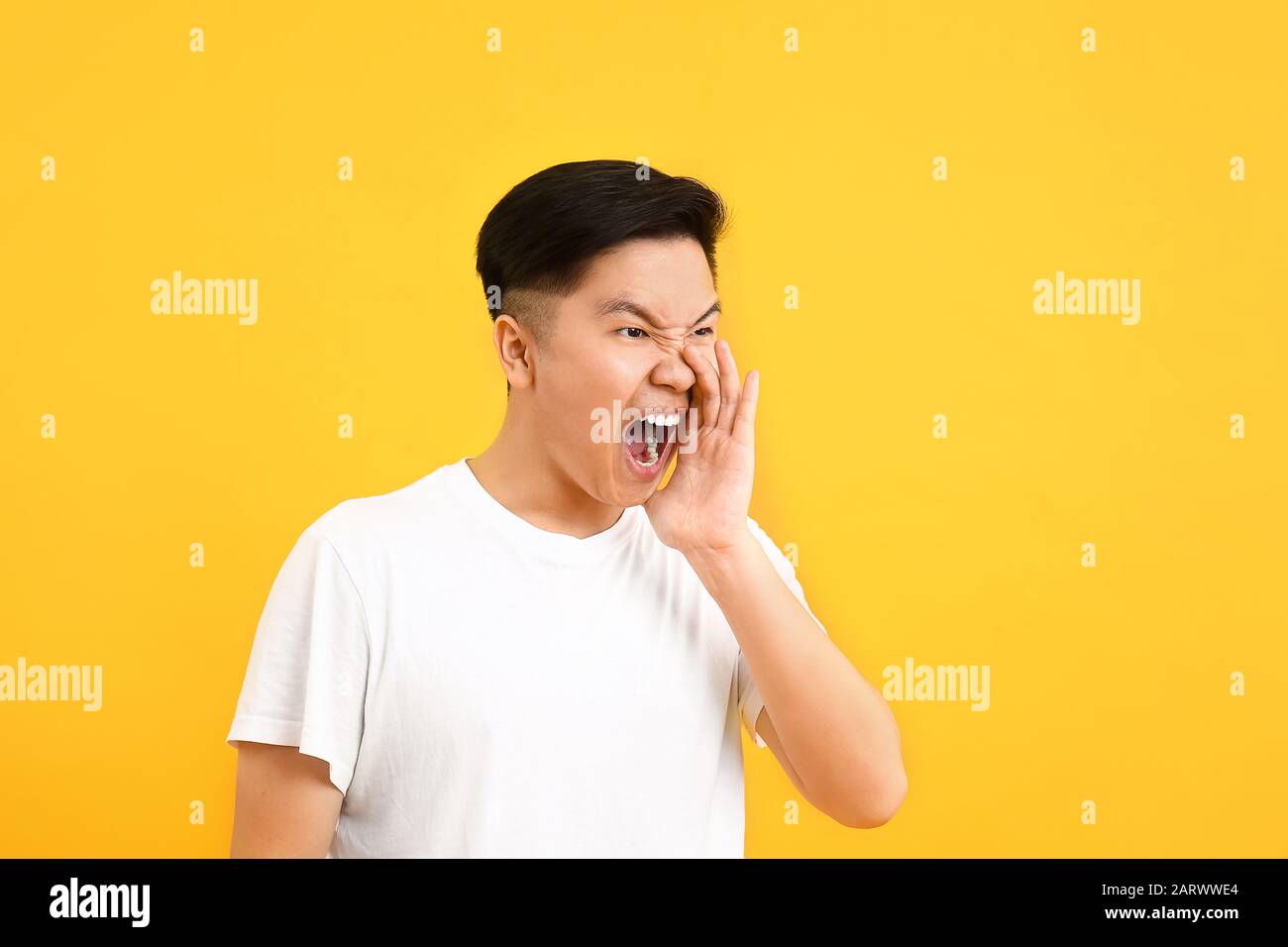 Portrait of screaming Asian man on color background Stock Photo - Alamy