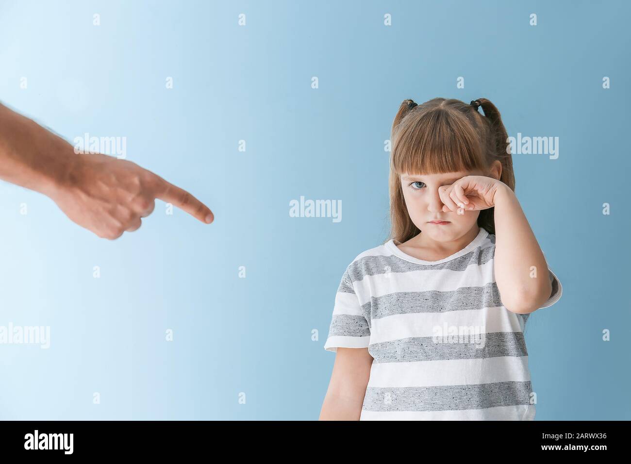 Angry father scolding his crying little daughter against color ...