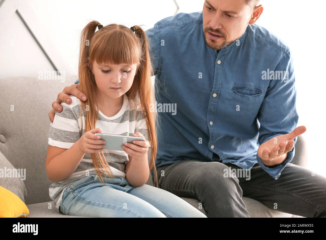 Little girl with mobile phone ignoring her angry father at home Stock ... Little girl with mobile phone ignoring her angry father at home Stock ...