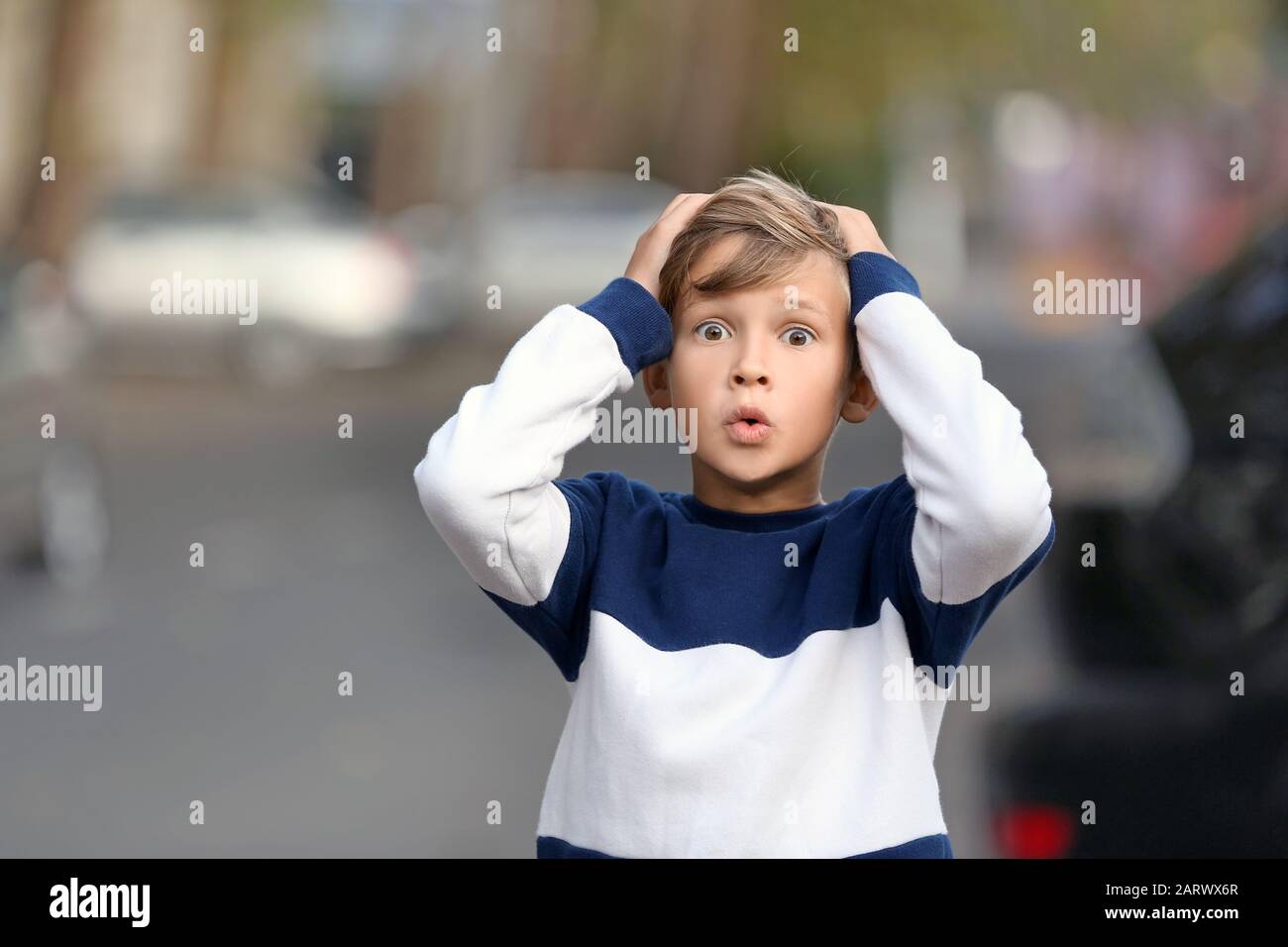 Surprised little boy walking outdoors Stock Photo - Alamy