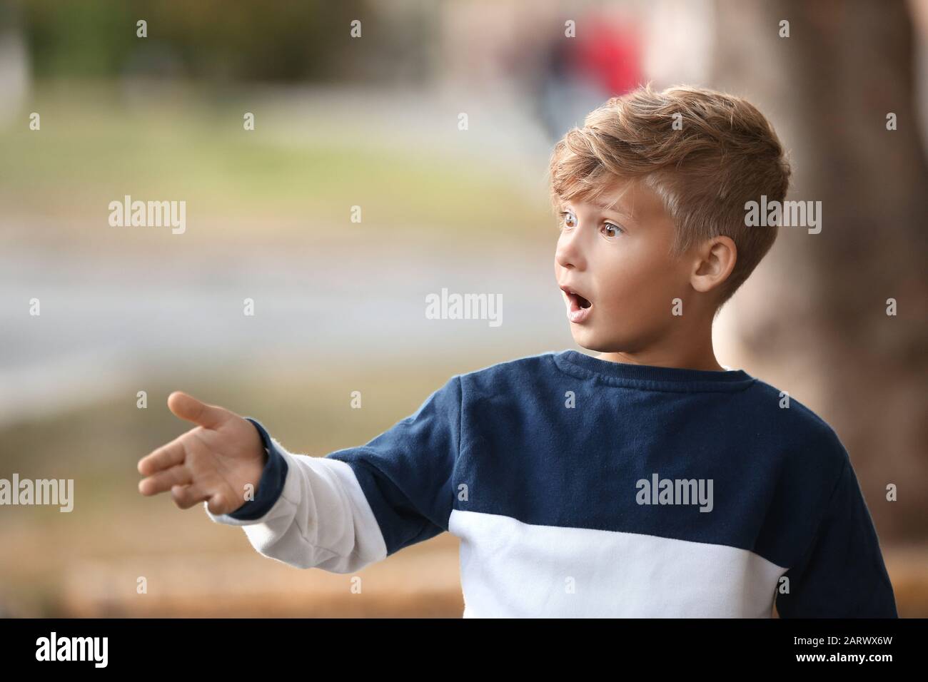 Surprised little boy walking outdoors Stock Photo - Alamy