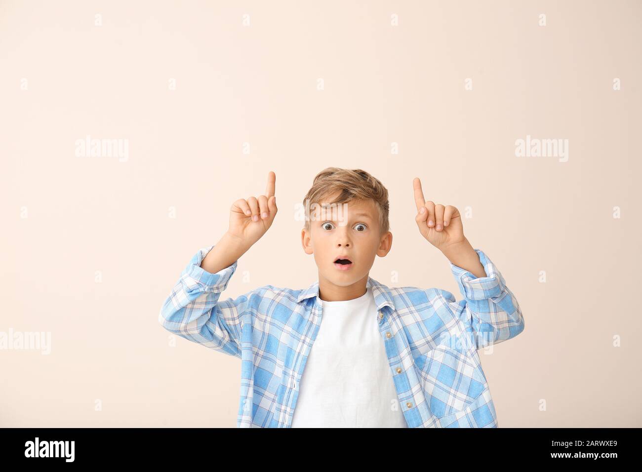 Surprised little boy pointing at something on white background Stock ...