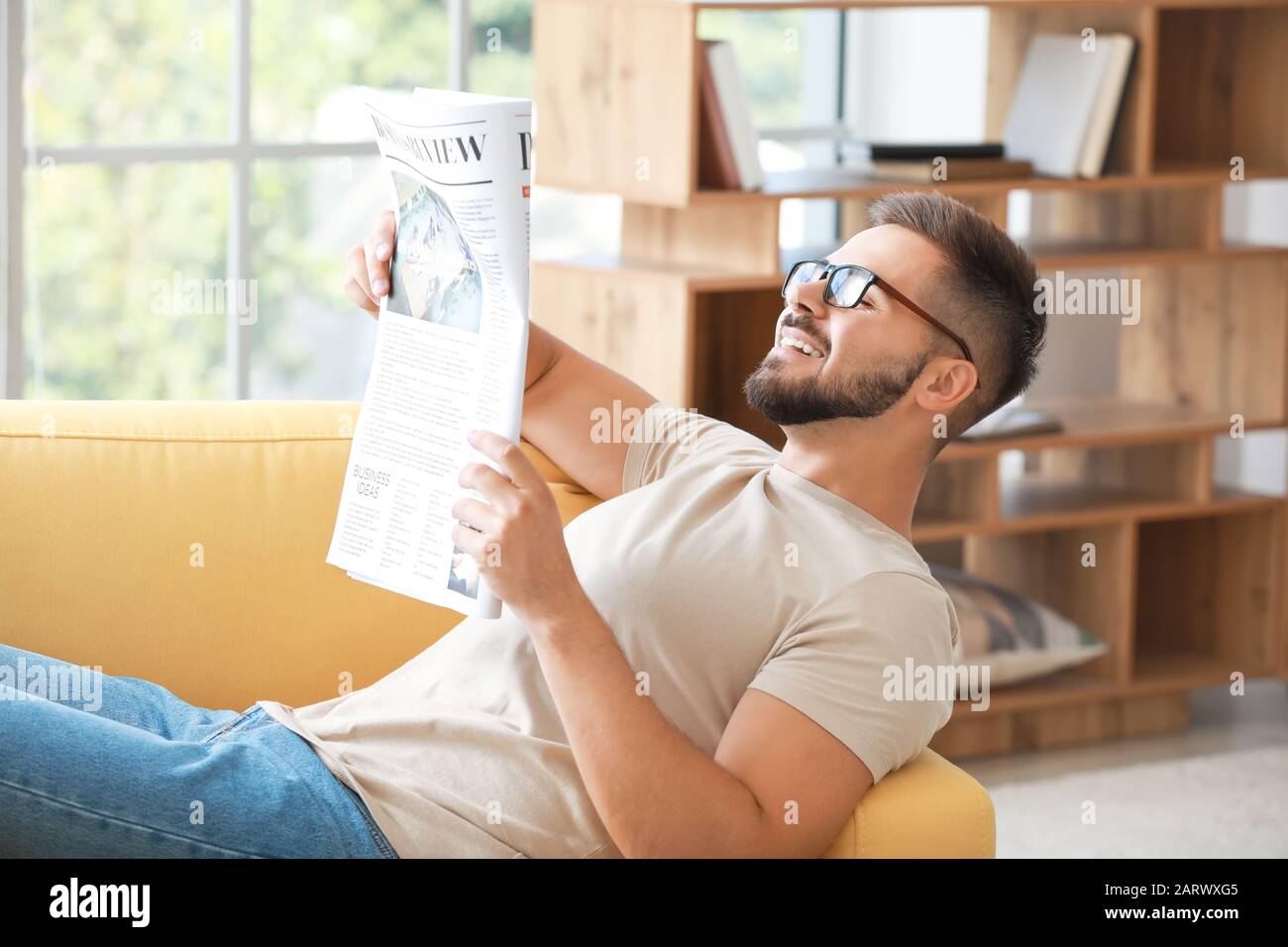Handsome man reading newspaper at home Stock Photo - Alamy