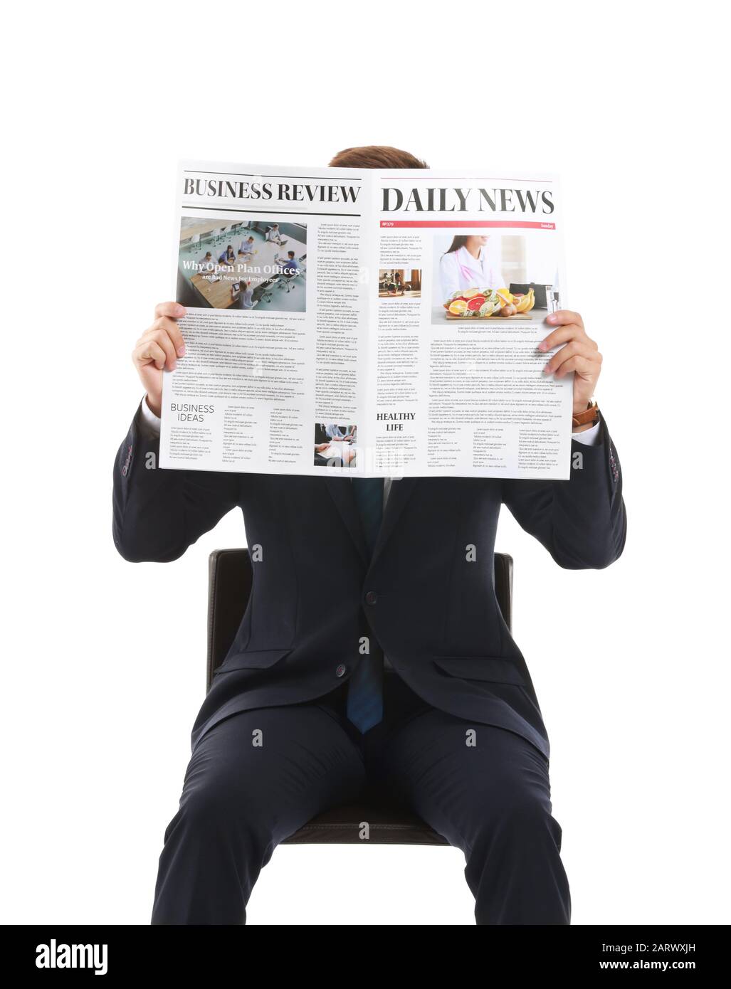 Handsome businessman with newspaper sitting on chair against white ...