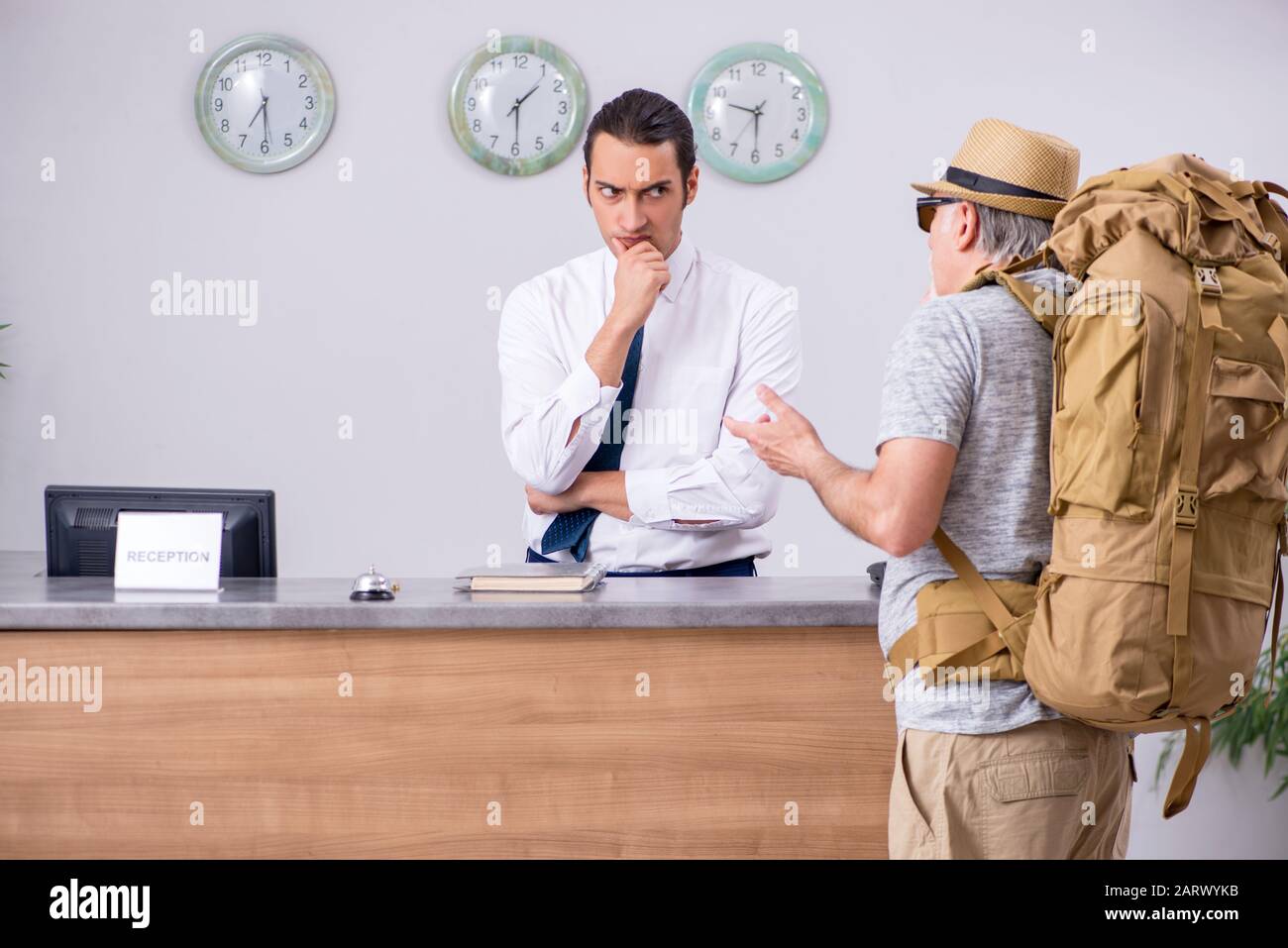 Old backpacker at the hotel reception Stock Photo - Alamy