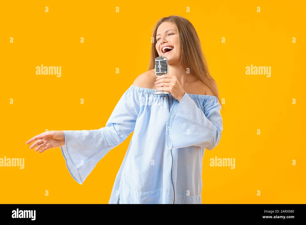 Beautiful young female singer with microphone on color background Stock ...