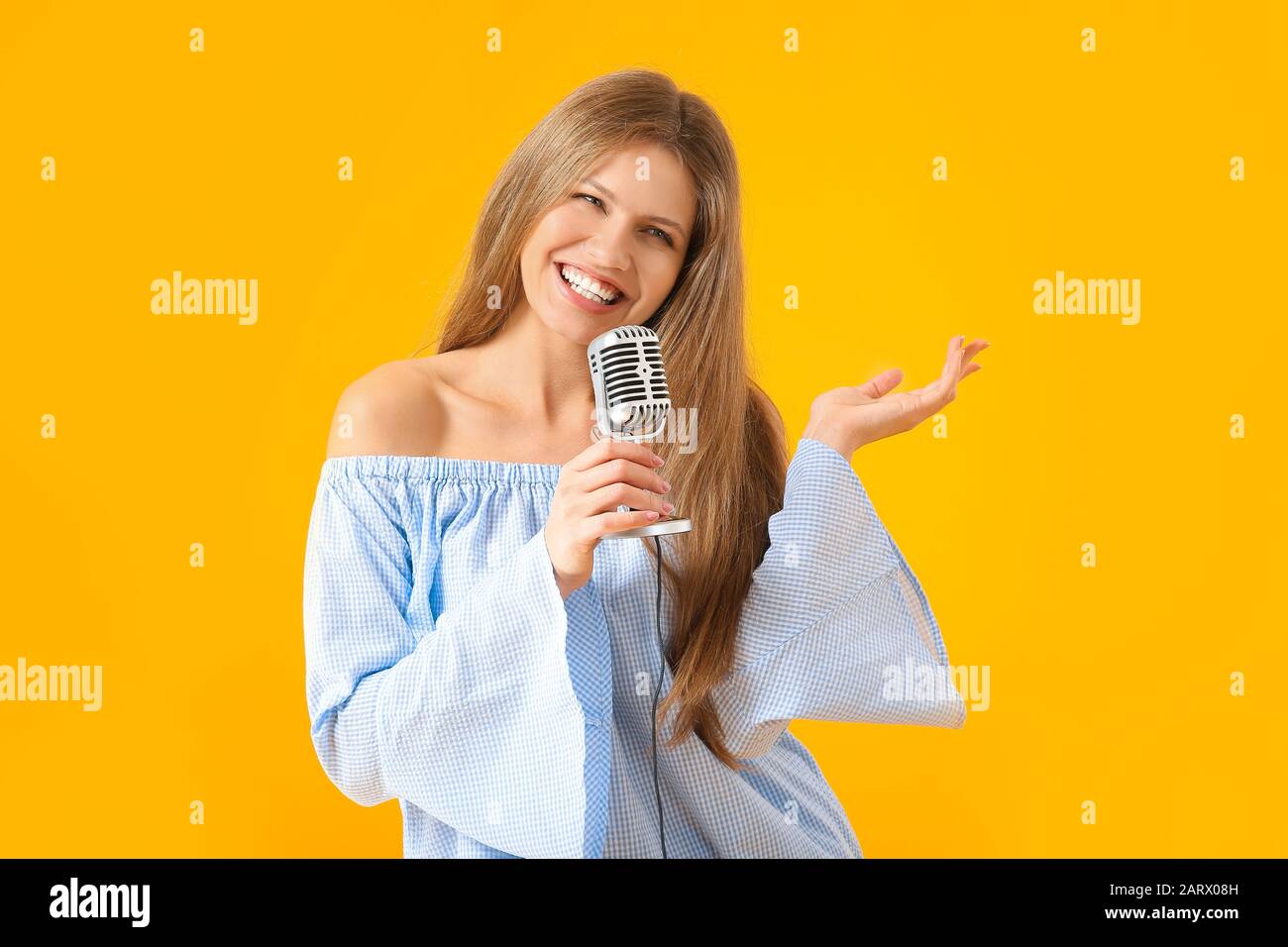 Beautiful young female singer with microphone on color background Stock ...