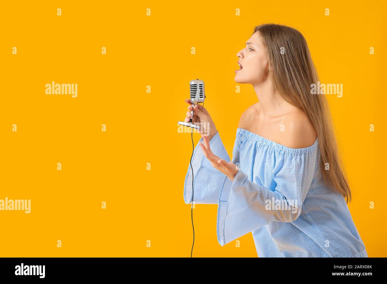 Beautiful young female singer with microphone on color background Stock ...