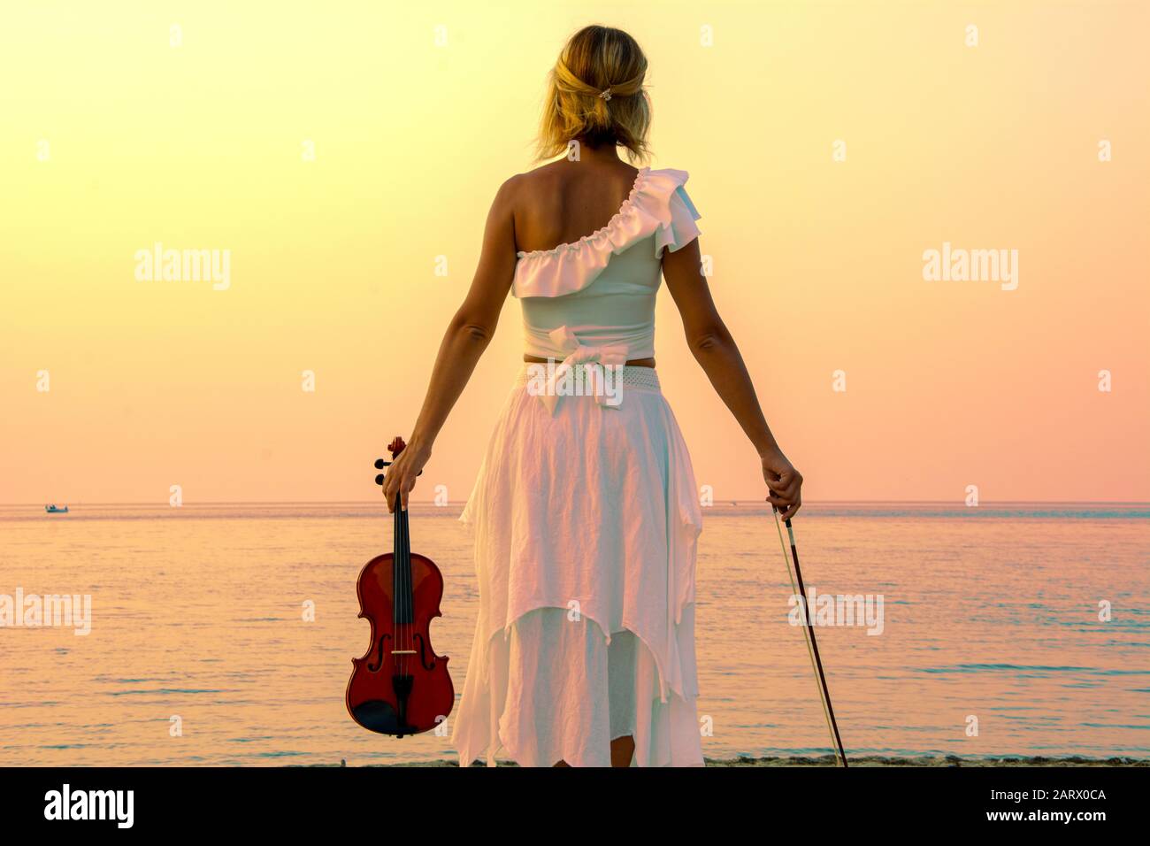 Beautiful woman playing violin at the sea with sunset background Stock ...