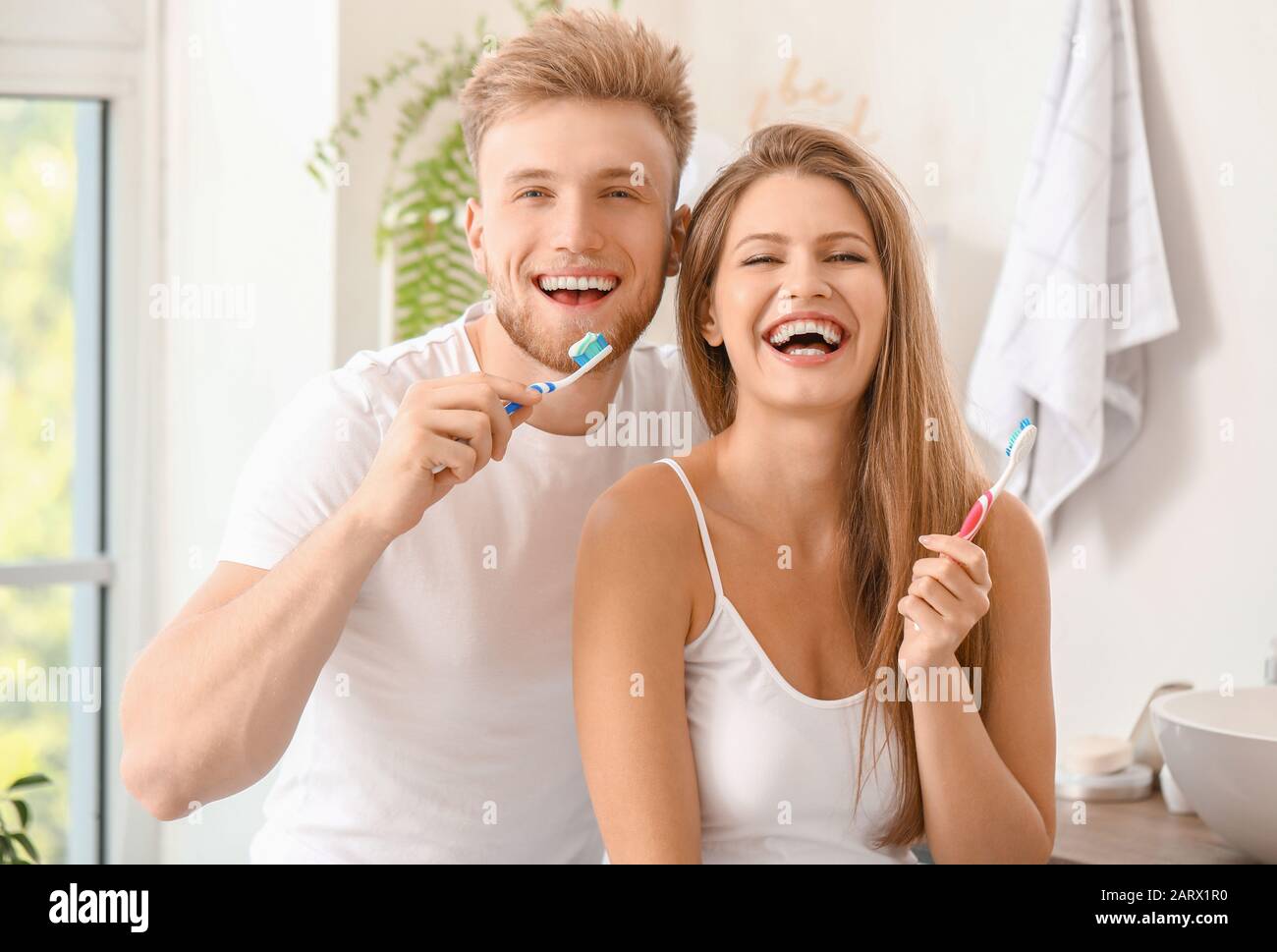Young couple brushing teeth at home Stock Photo - Alamy