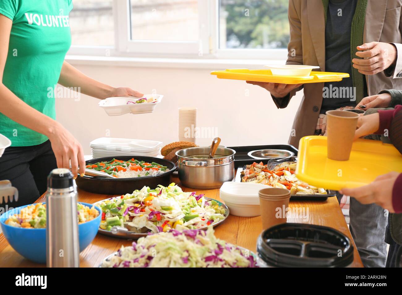 Volunteers giving food to homeless people Stock Photo - Alamy