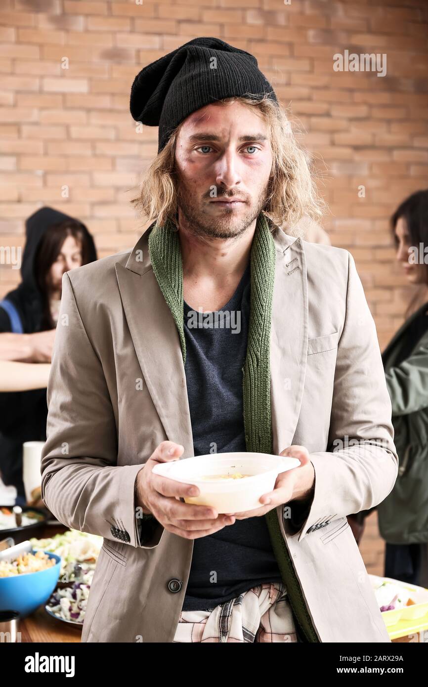 Homeless man with food received from volunteers Stock Photo - Alamy